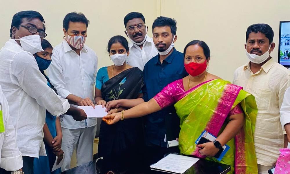 KTR hands over cheque to deceased TRS leader's family