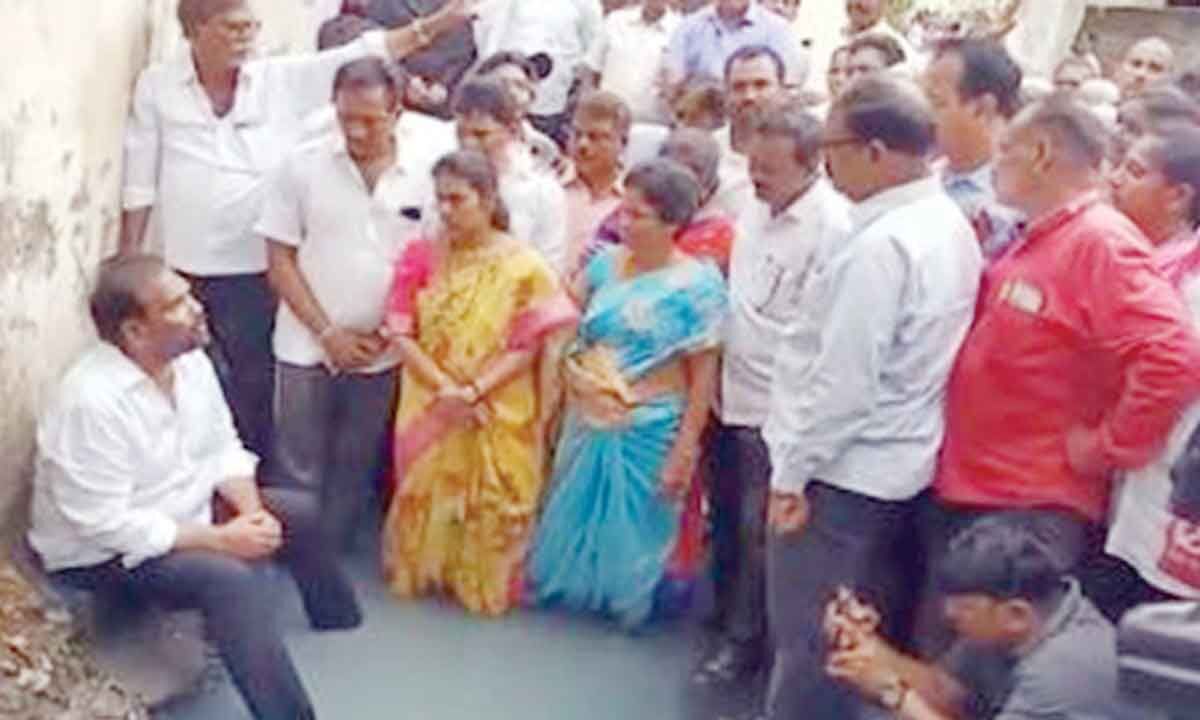 MLA Kotamreddy Sridhar Reddy sits in the drain to protest delay in works